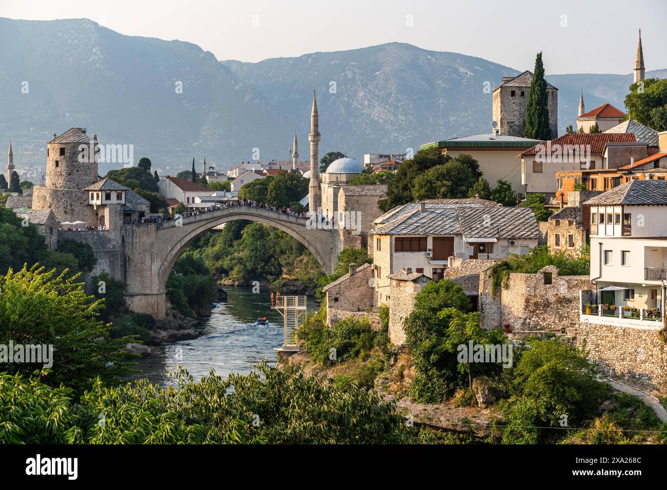 This photo captures a river running through Mostar city, with a ...