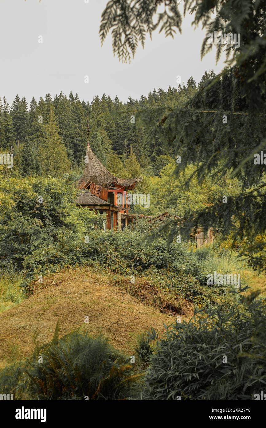 A cozy cottage surrounded by trees, accessible via a winding path Stock ...