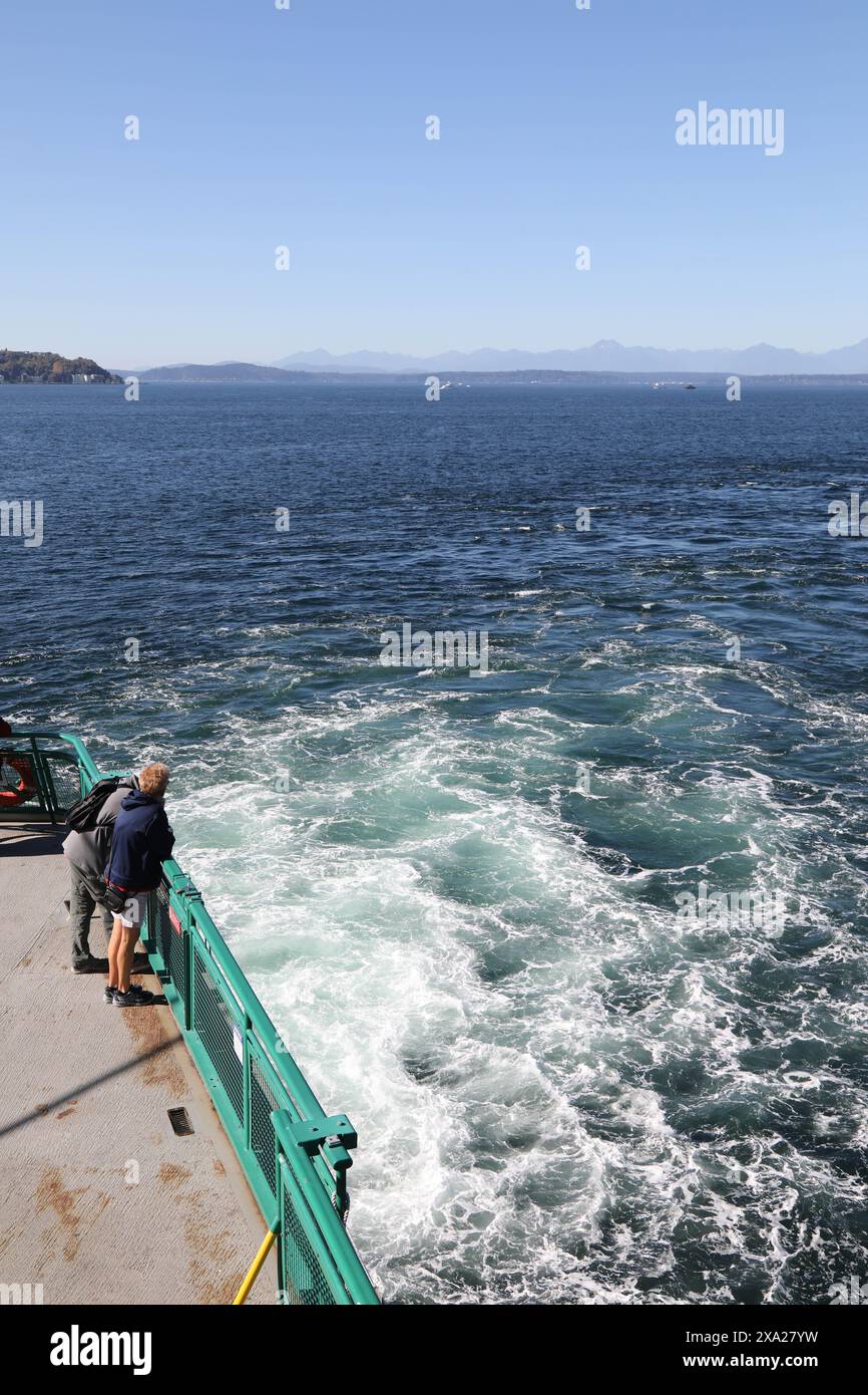 Some people load boat onto ocean behind dock Stock Photo - Alamy