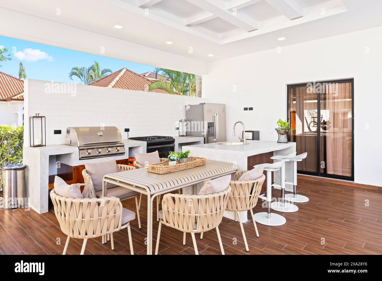 A patio with an outdoor kitchen, table, and chairs in a cozy room Stock ...