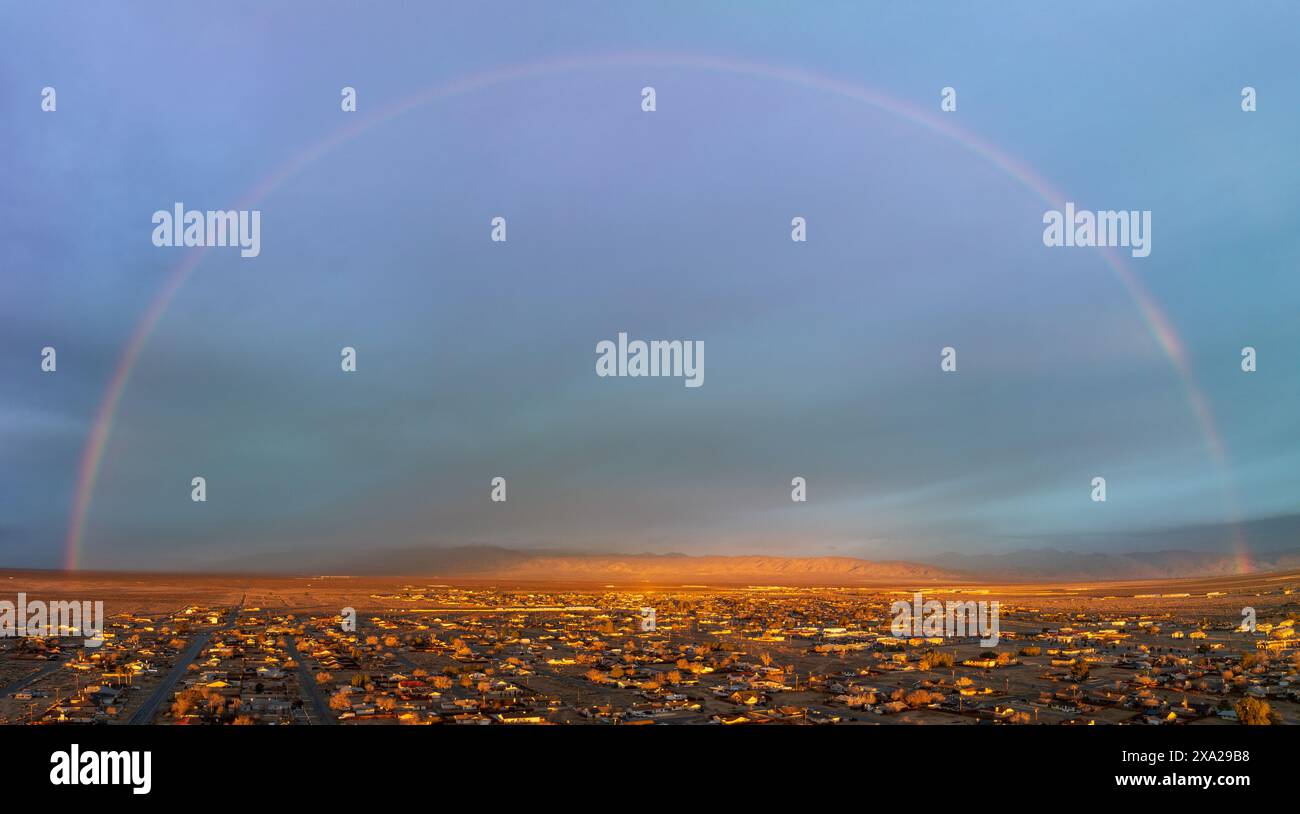 Cityscape in vast expanse with colorful rainbow arcing overhead Stock ...