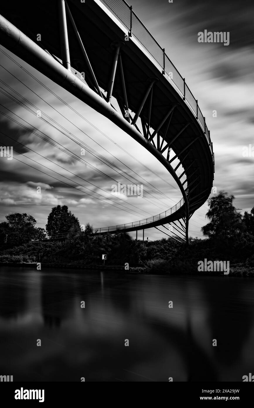 Blurred motion bridge over river under cloudy sky Stock Photo - Alamy