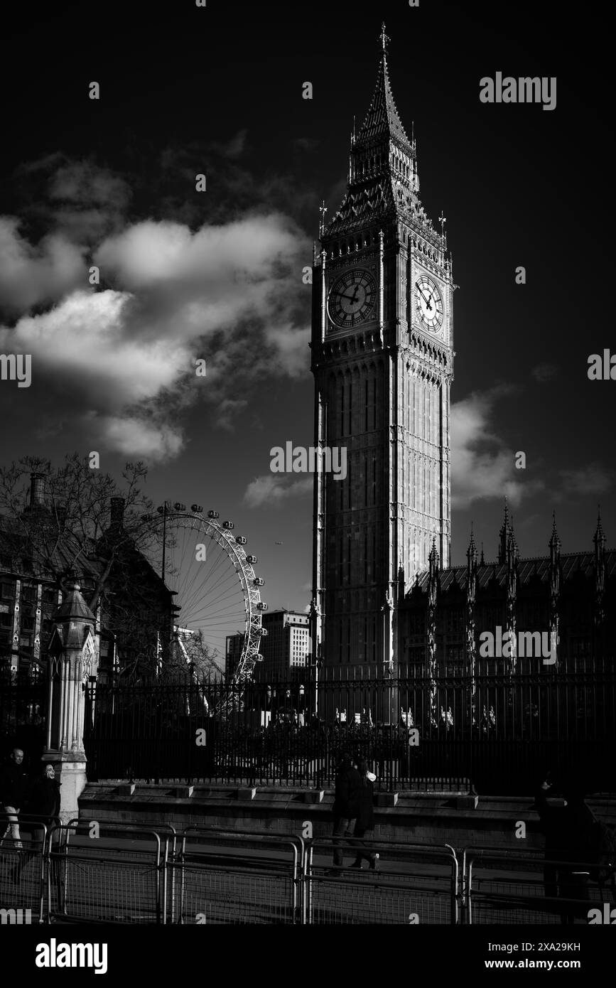 The tall Big Ben stands beside a building with a ferris wheel nearby ...