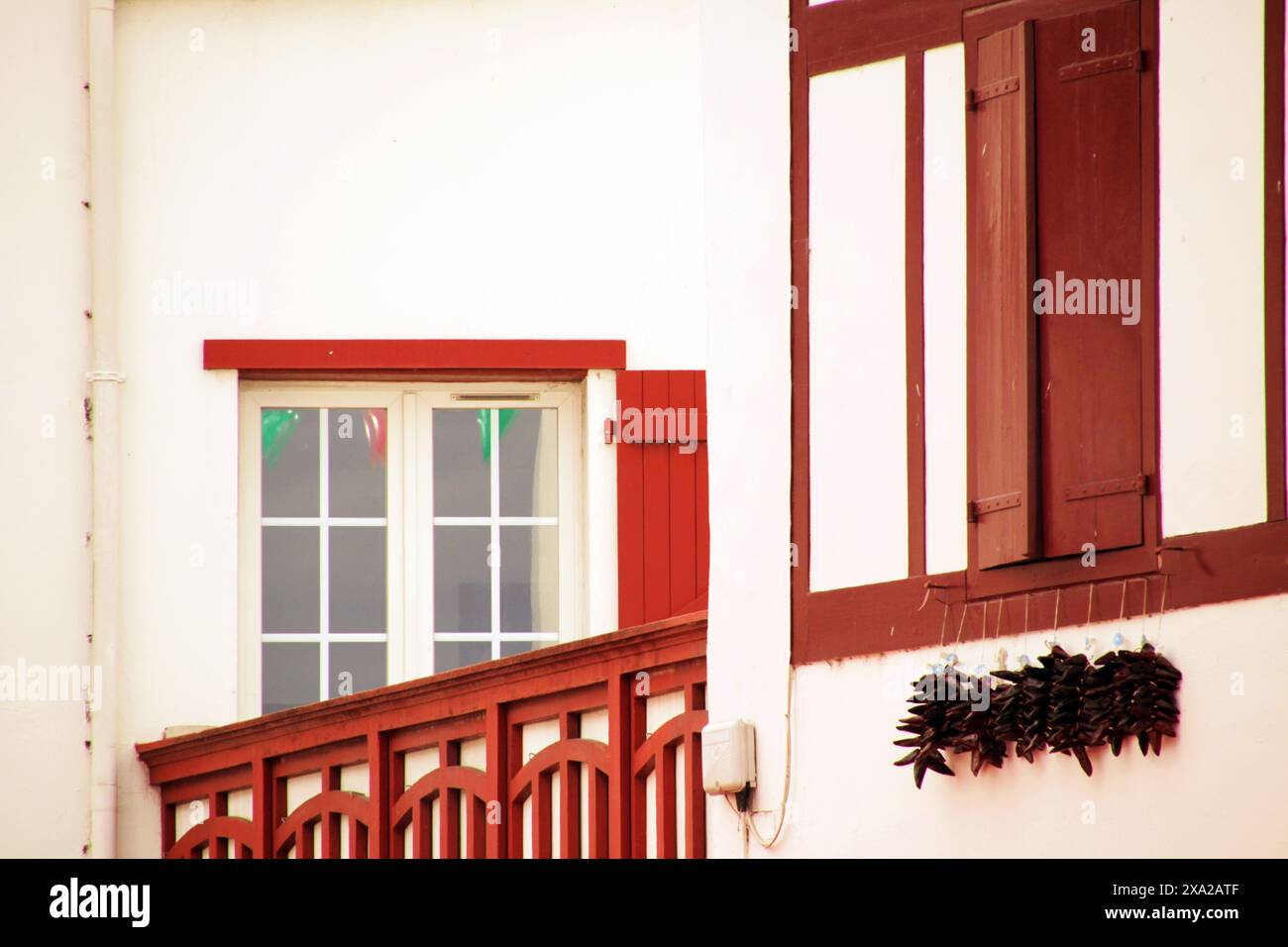 Red peppers hanging on the facade of a Basque-style house in Espelette ...