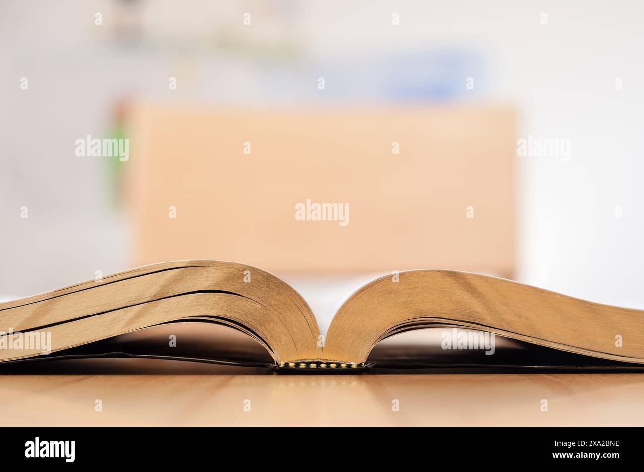 An open book resting on a table surface Stock Photo - Alamy