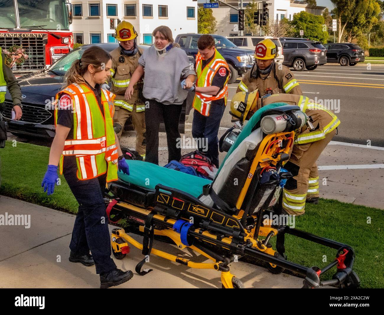 Firemen paramedics treat a female automobile traffic accident victim on ...