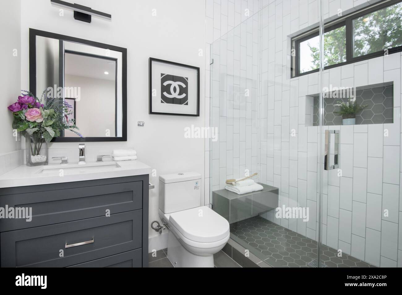 A compact bathroom with toilet, sink, and shower area in a modern new ...