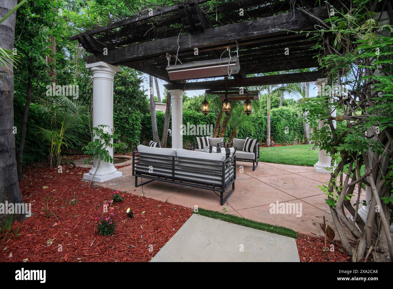 An outdoor seating area with sofas and a coffee table in a modern new ...