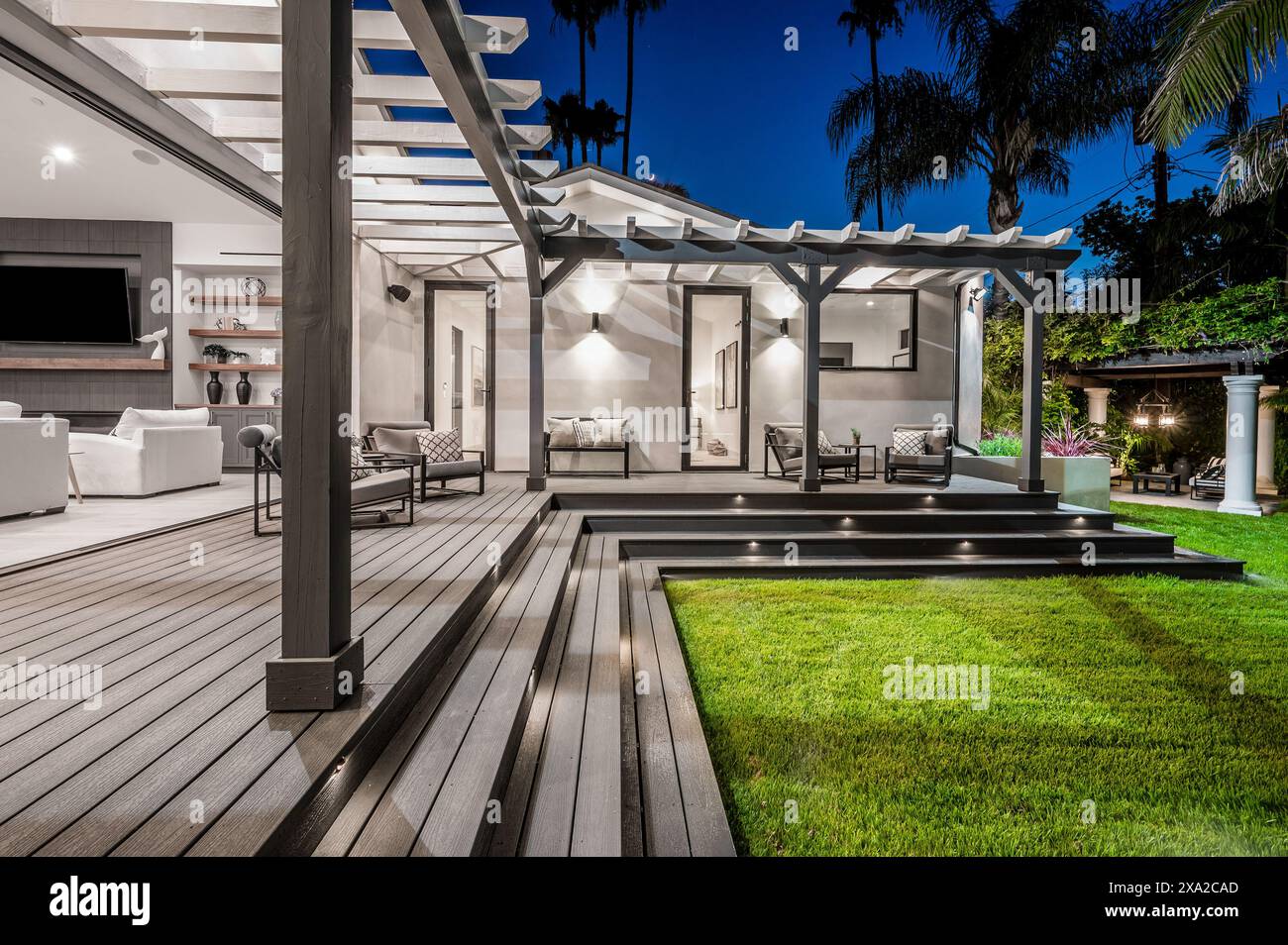 An outdoor seating area with sofas and a coffee table in a modern new ...