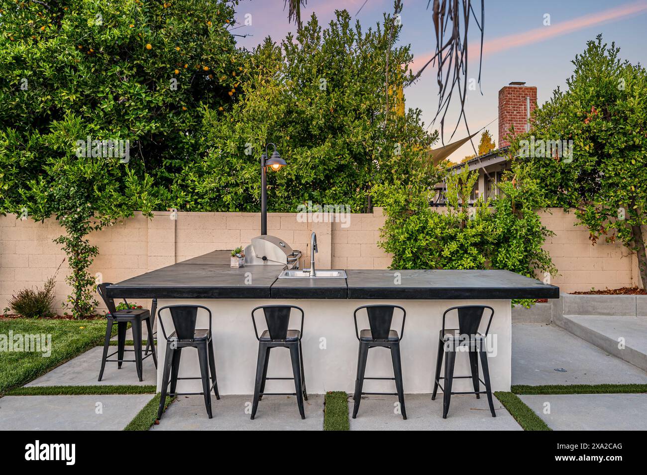 An outdoor counter with chairs in a modern new construction home in Los ...