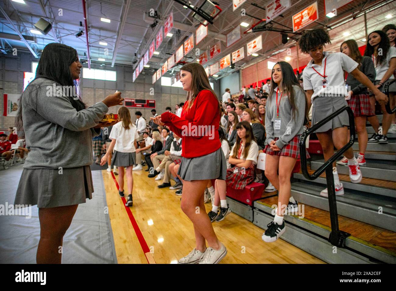 Multiracial uniformed students at a Southern California Catholic high school participate in ...