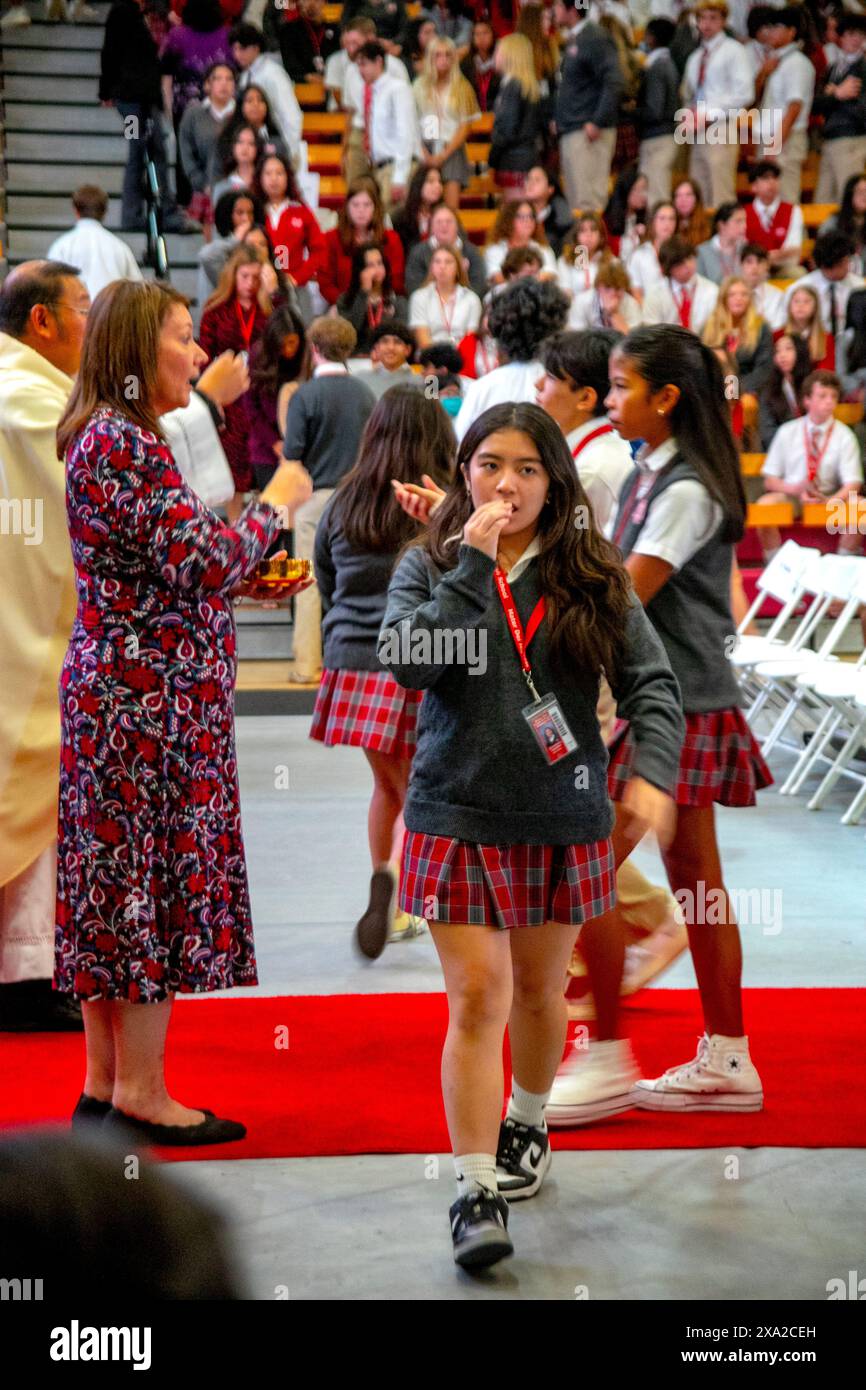 Multiracial uniformed students at a Southern California Catholic high school participate in ...