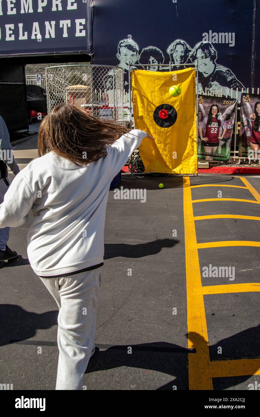 A Southern California high school girl throws balls at a target during ...