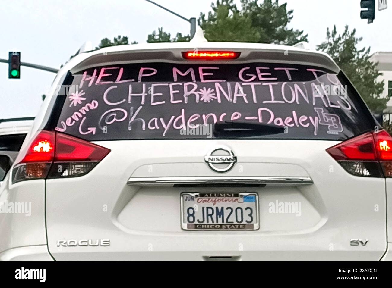 An ambitious cheerleader's hand made sign on the rear window of a ...