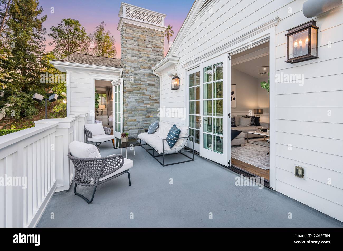 A balcony with a sofa, chairs, and an open door in a new construction ...