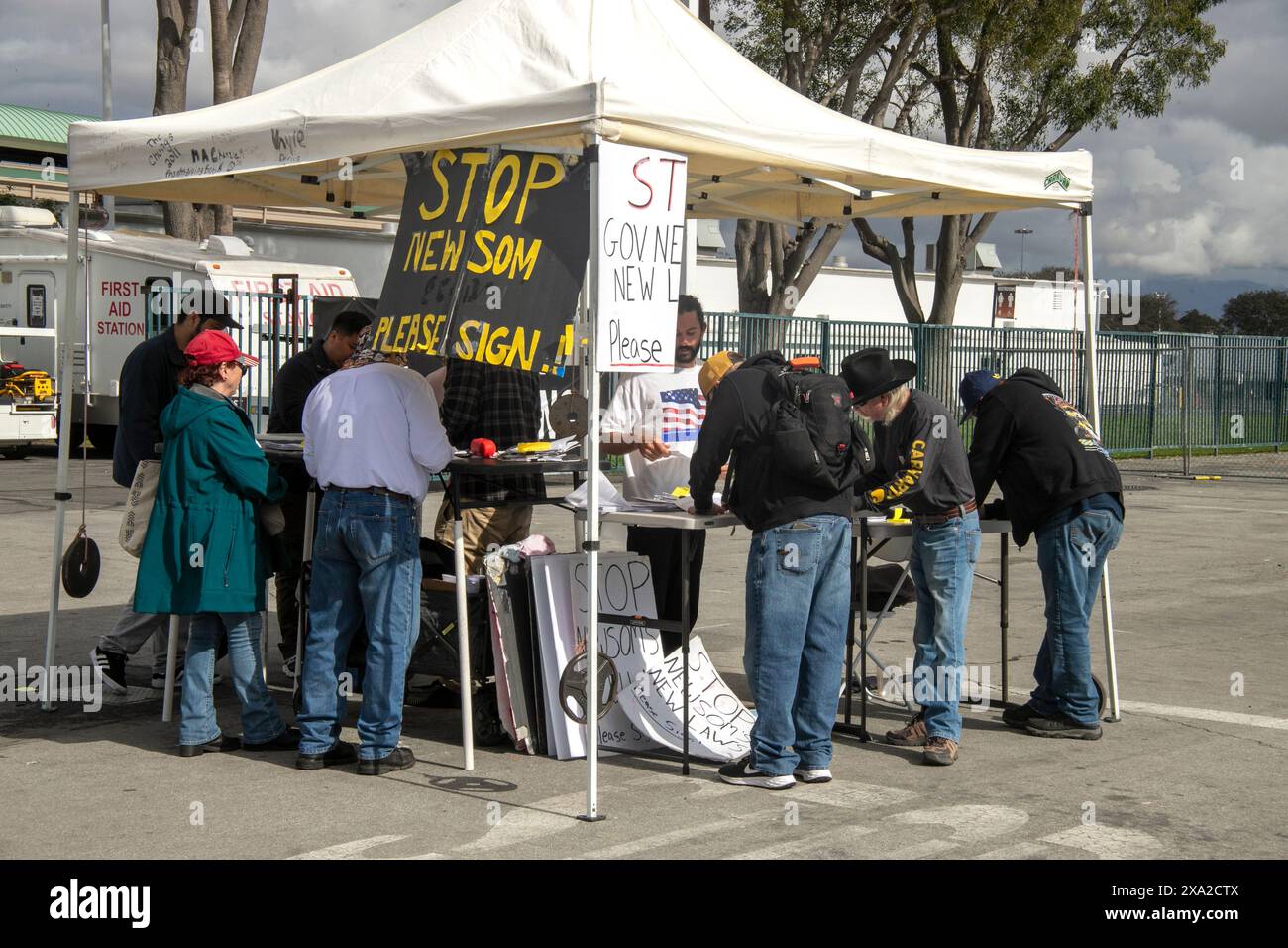 Under a canopy at a gun show in Costa Mesa, CA, gun owners sign a ...