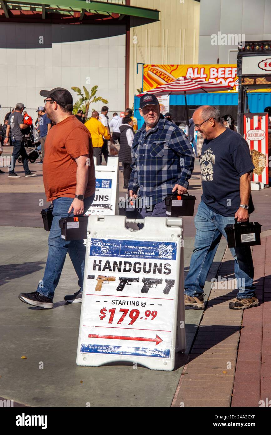 Three happy ammunition purchasers walk past signs advertising weapons ...