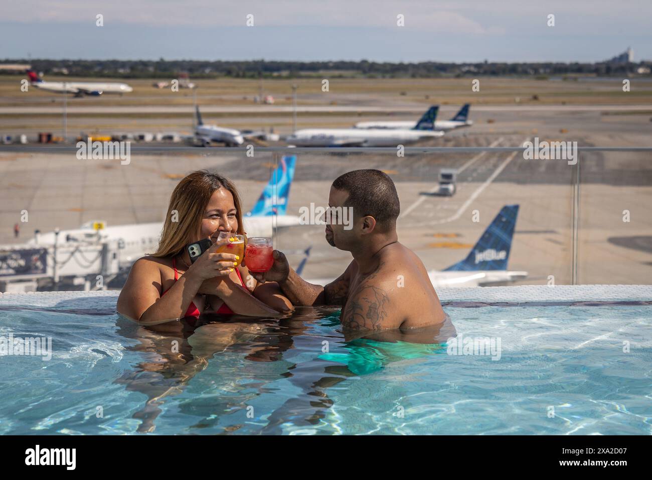 A couple enjoying cocktails in a pool on the roof of the TWA Hotel at JFK Airport in New York ...