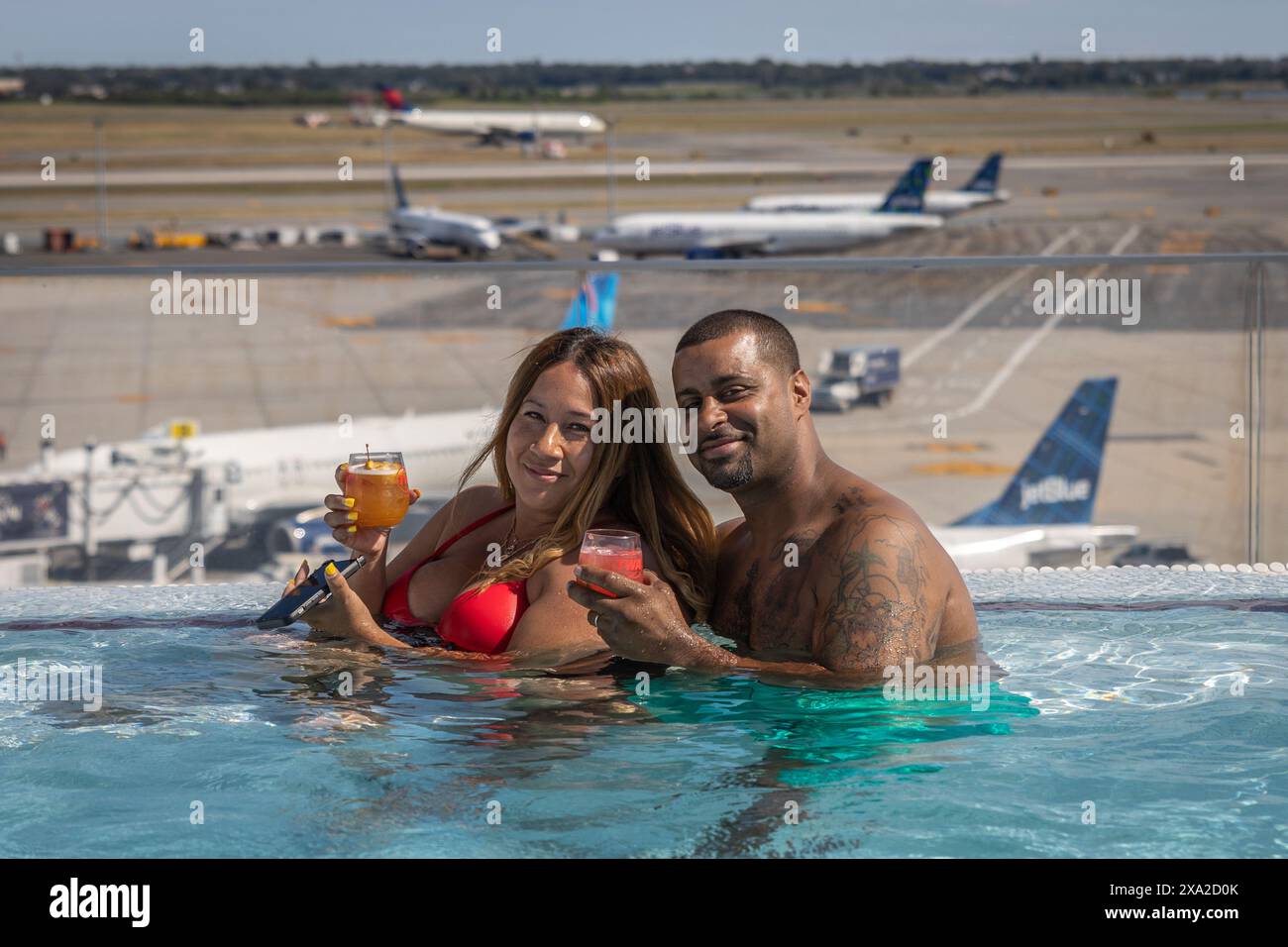 A couple enjoying cocktails in a pool on the roof of the TWA Hotel at JFK Airport in New York ...