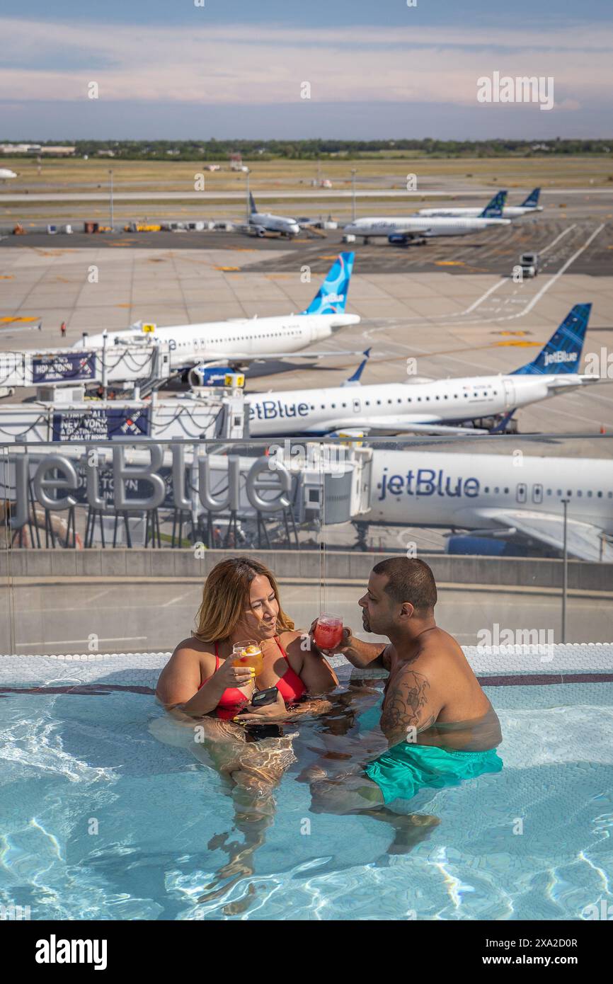 A couple enjoying cocktails in a pool on the roof of the TWA Hotel at JFK Airport in New York ...
