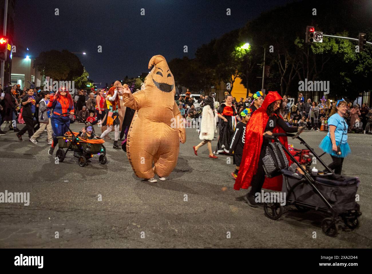 Costumed multiracial participants march in a night time Halloween ...