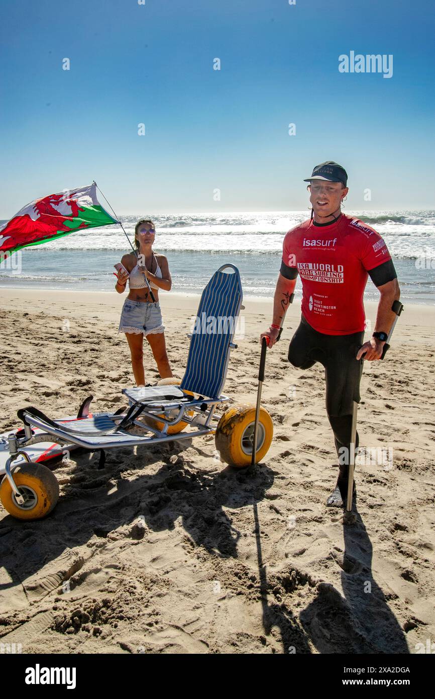 A parasurfer amputee uses crutches while a companion waves the dragon ...