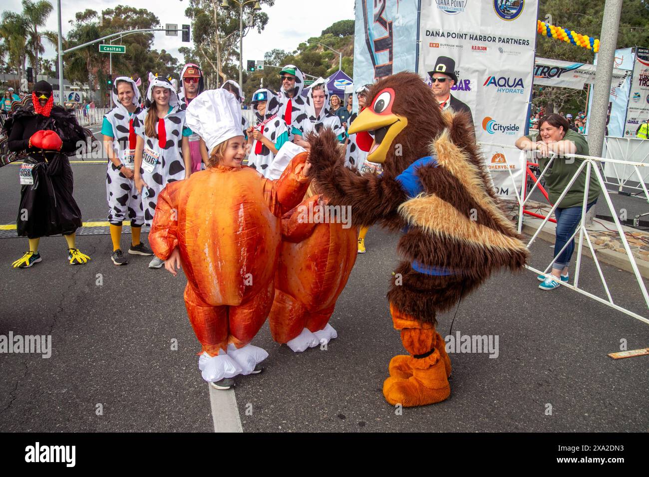 An entertainer in a turkey costume greets a brother and sister in ...