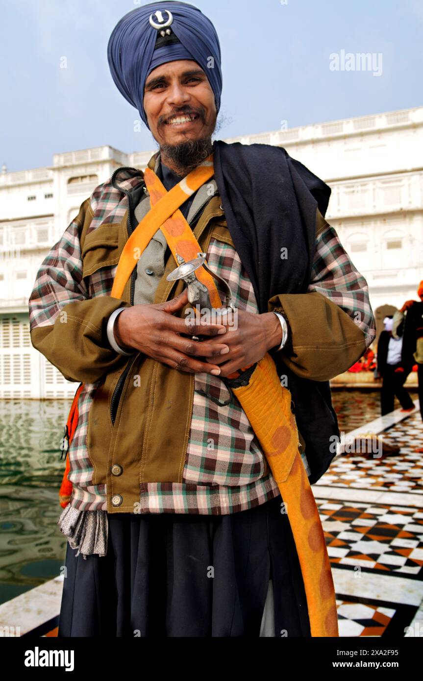 A Sikh Nihang sitting by the pond of the Golden Temple in Amritsar ...