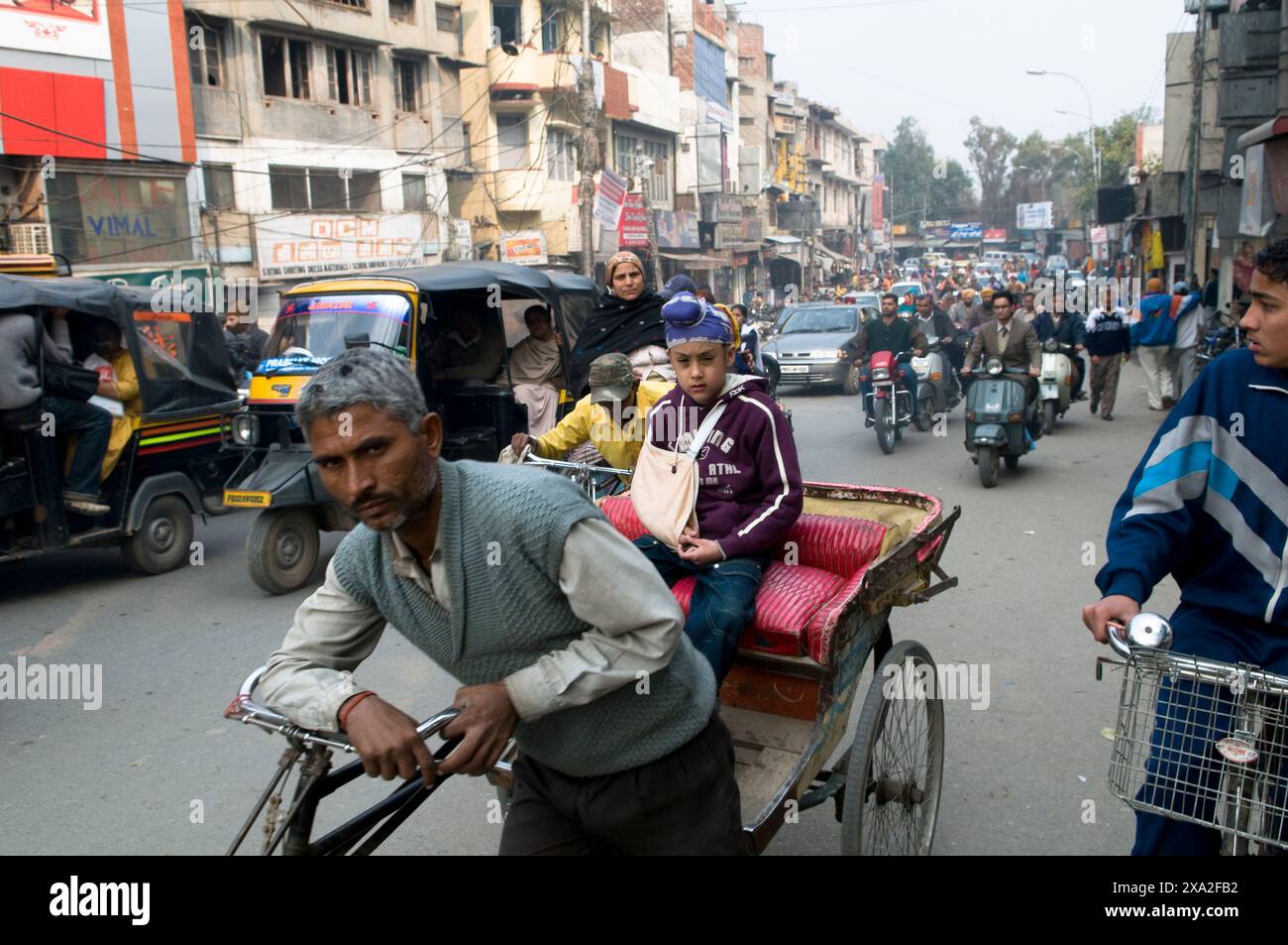 Busy street packed with cycle rickshaws and people is a common scene in ...