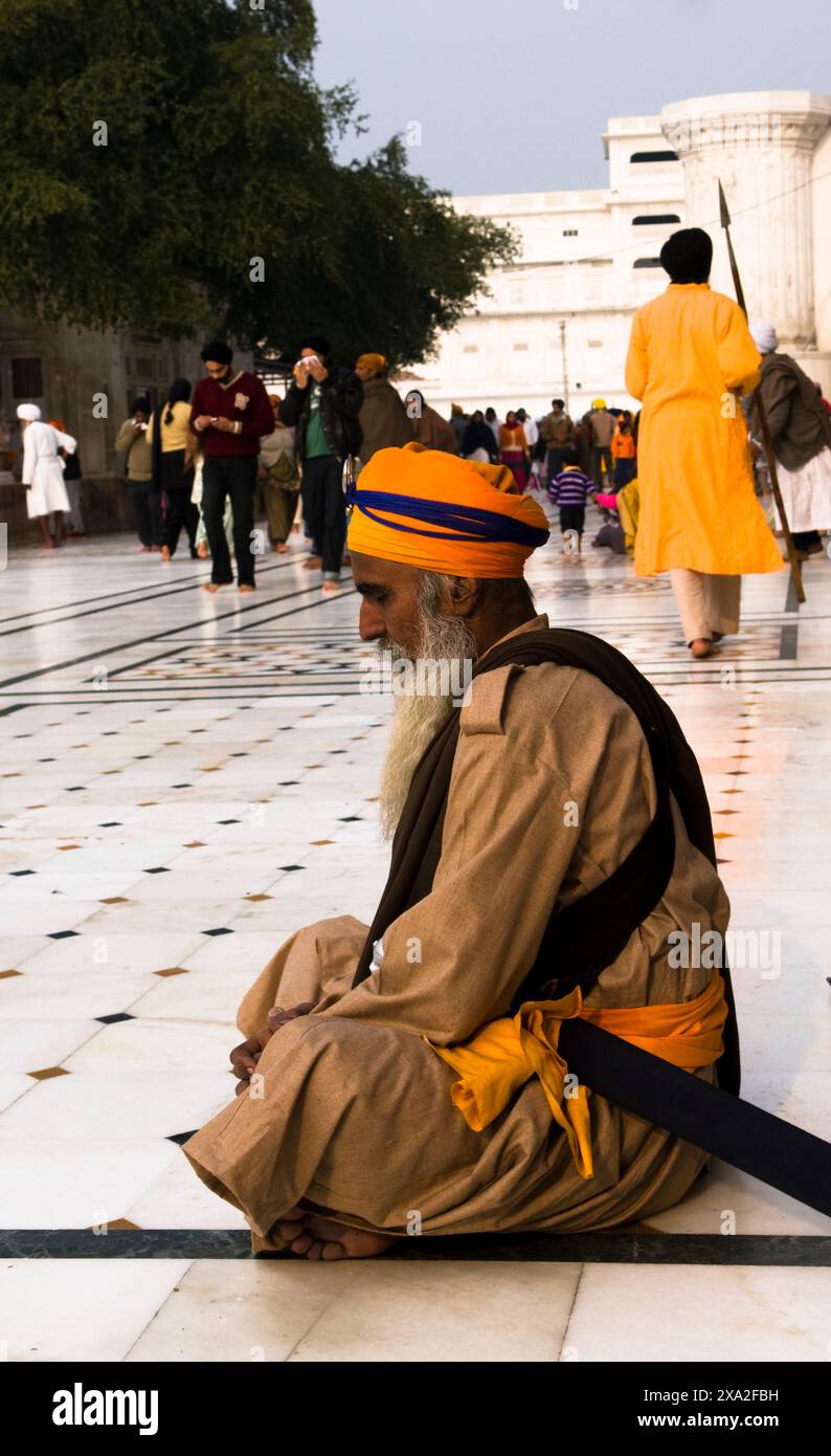 A Sikh Nihang sitting by the pond of the Golden Temple in Amritsar ...