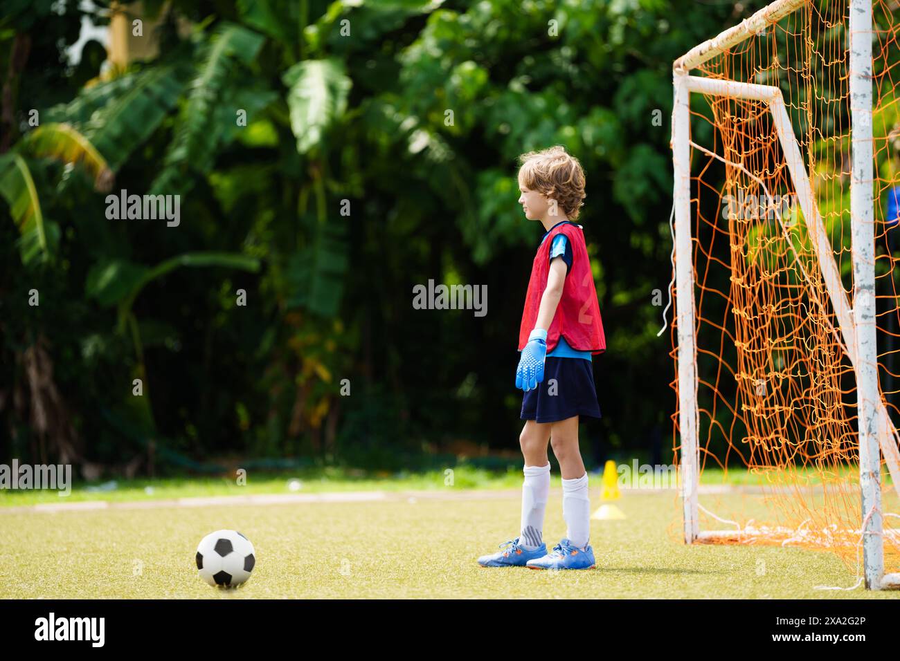 Child playing football. Kids play soccer on outdoor pitch. Little boy ...
