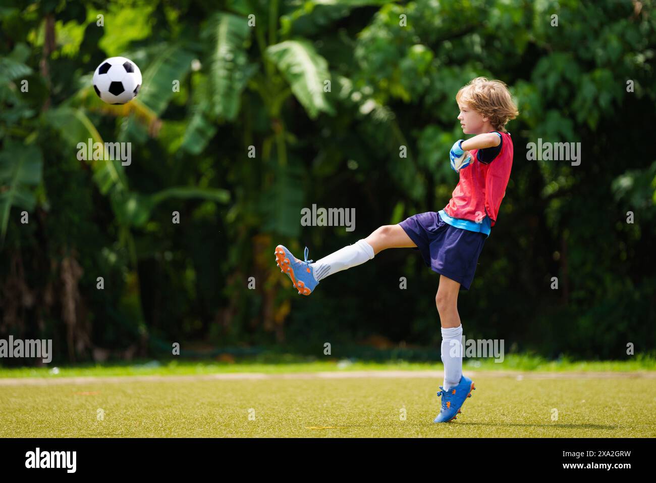 Child playing football. Kids play soccer on outdoor pitch. Little boy ...