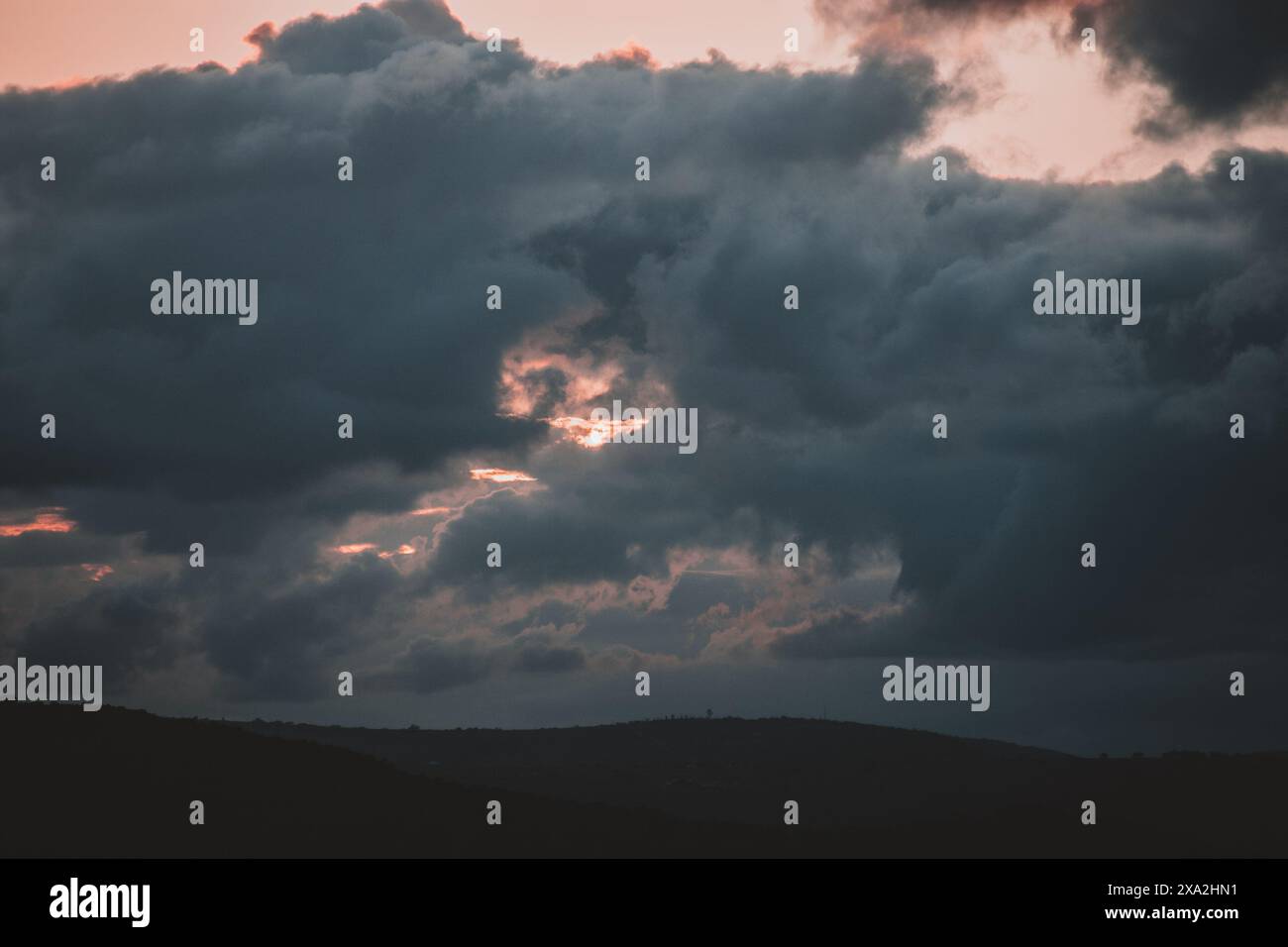 A dramatic and moody sunset with dark clouds rolling over the South ...