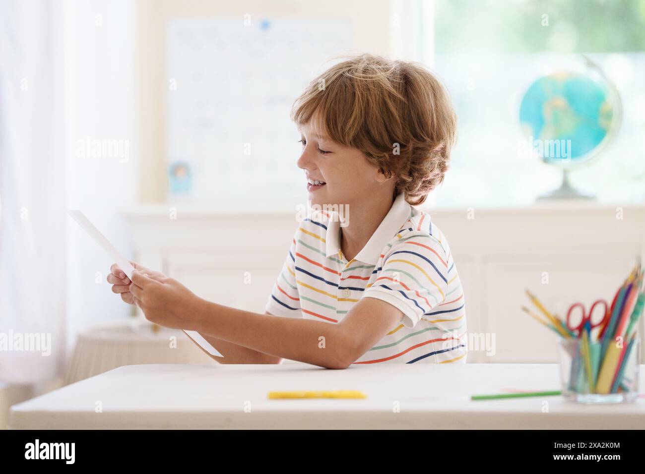 Child holding school test with excellent A grade. Student happy after ...