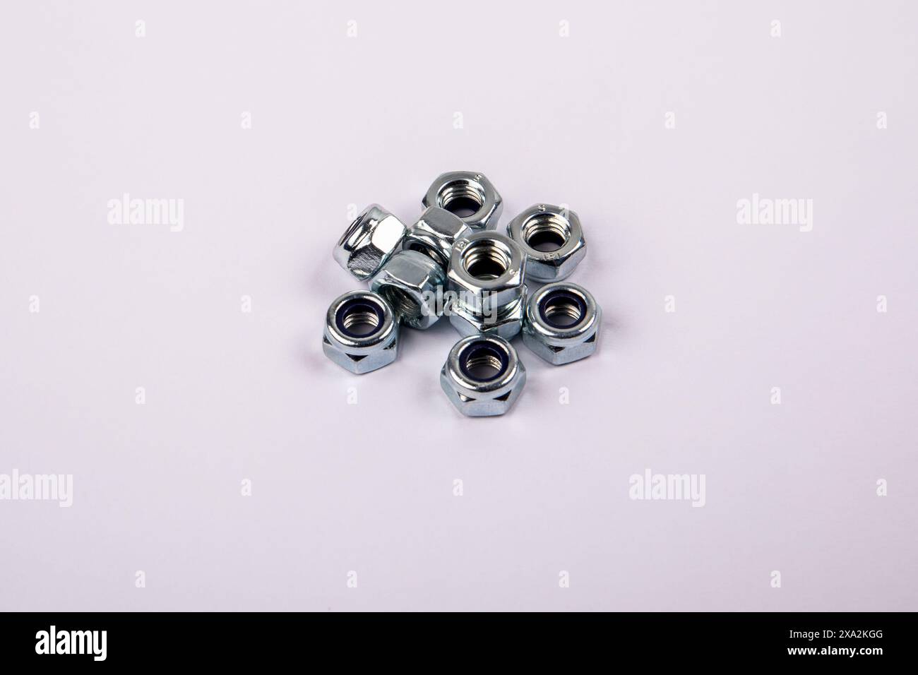 Stack of zinc plated self locking hexagon nuts on white background ...