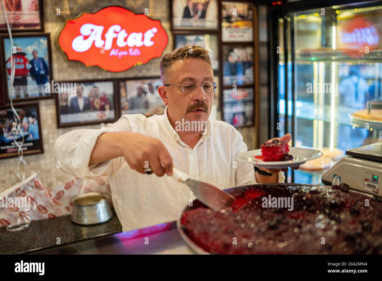 A shopkeeper serves the famous bread crumb dessert. Afyonkarahisar, a ...