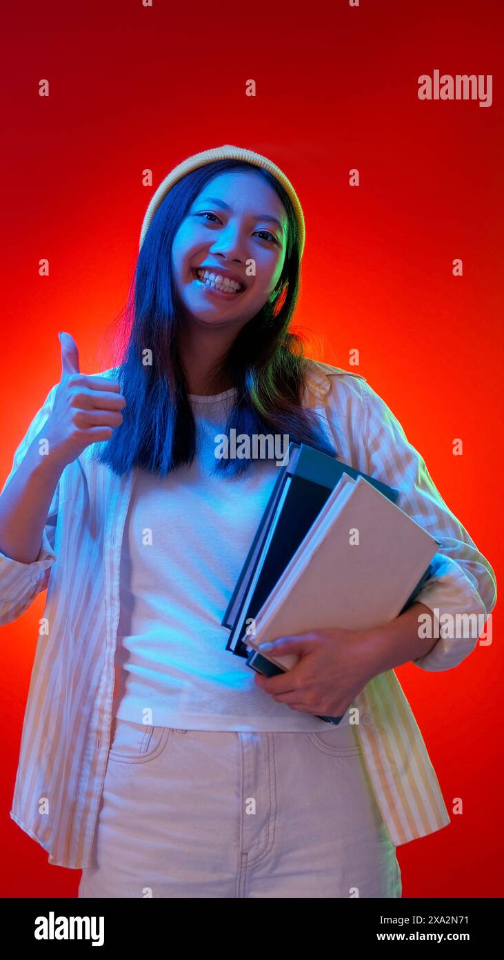 Cool study. Successful education. Satisfied cheerful girl with books showing thumb up like ...