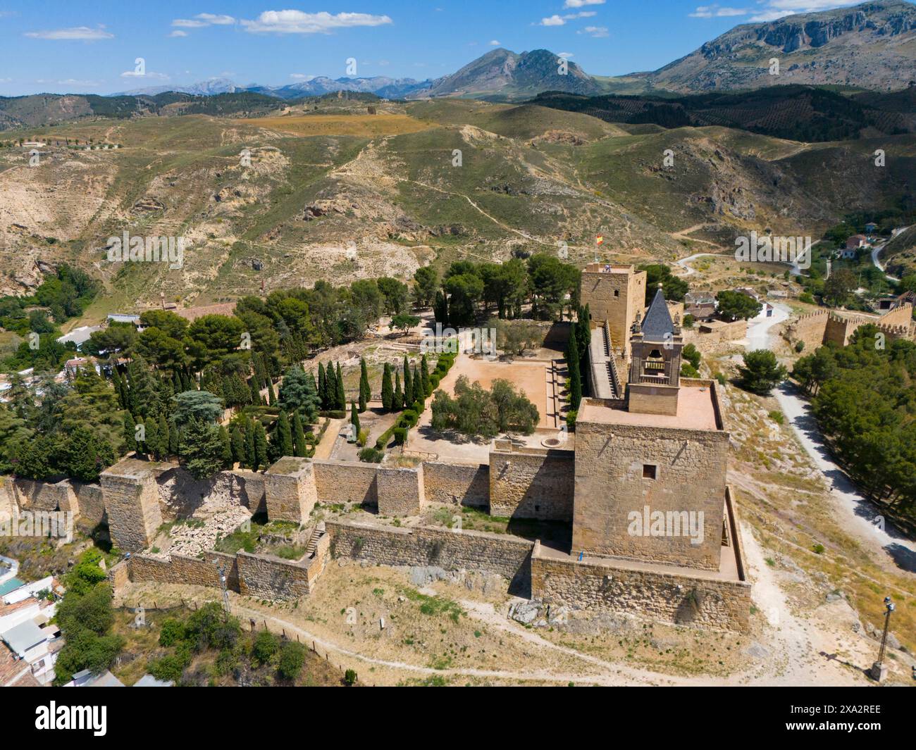 Aerial view of a historic fortress, surrounded by trees and mountains ...
