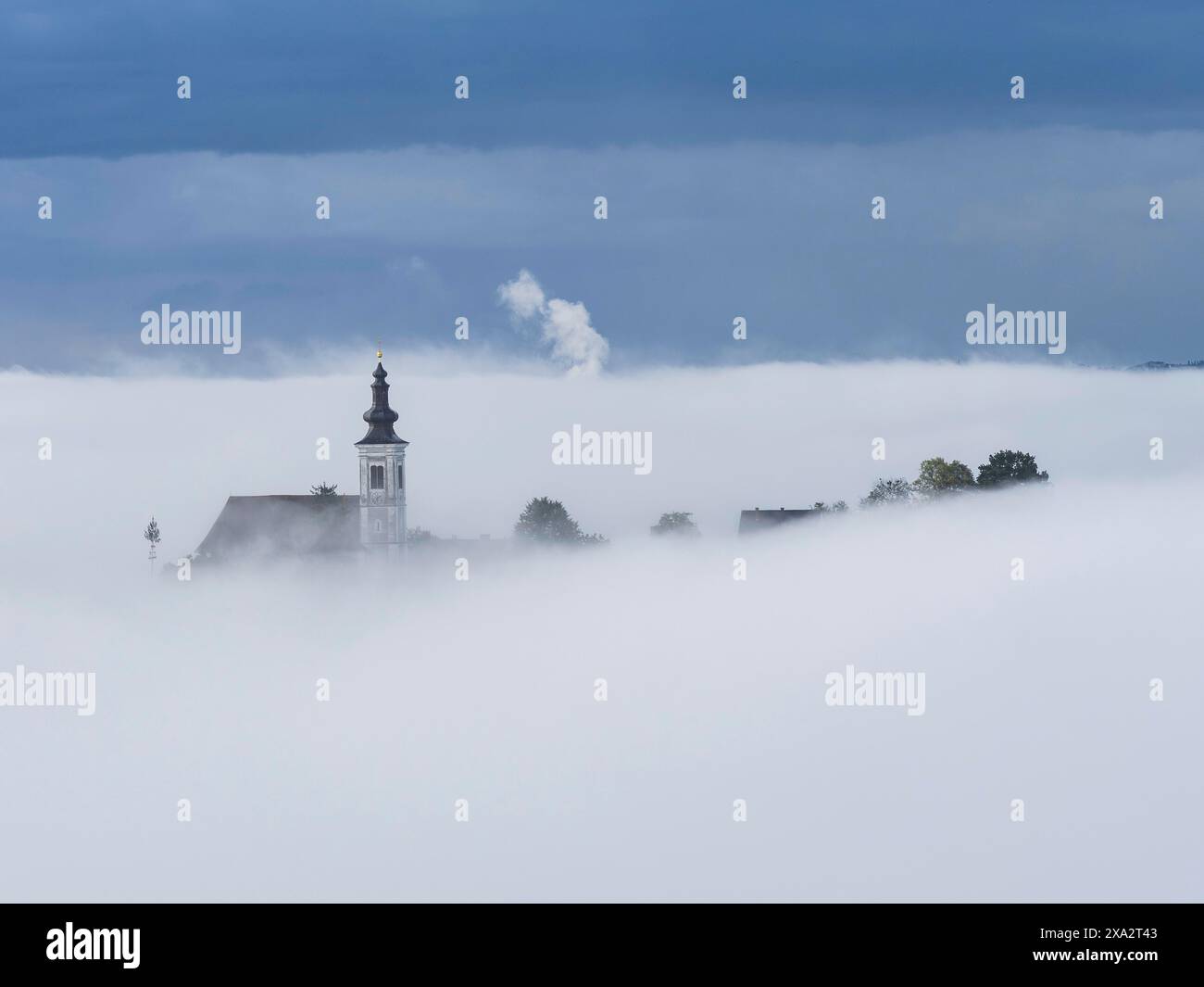 Church tower rises out of the morning mist, Frauenberg pilgrimage ...