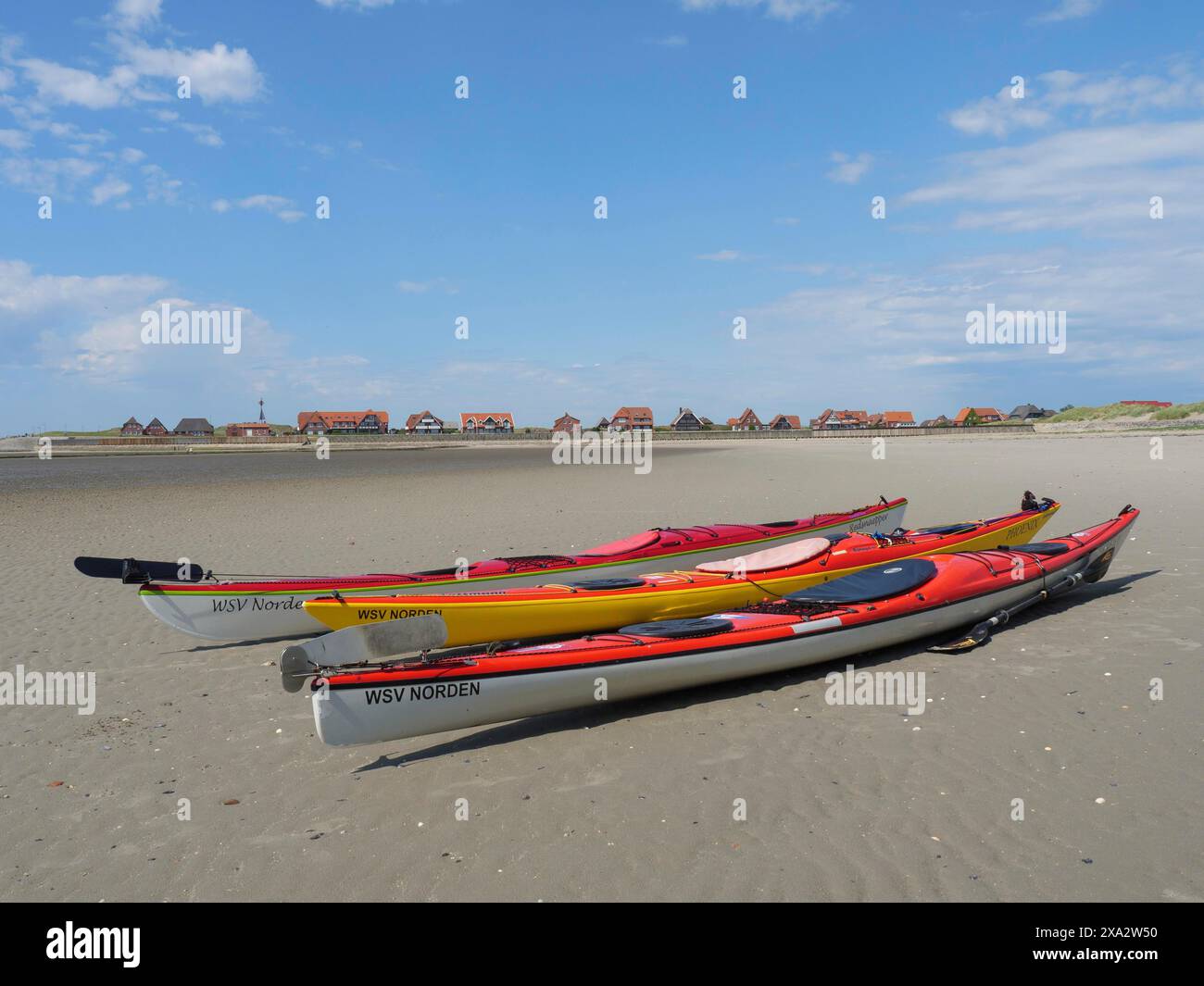 Kayaks on the beach with village in the background, Baltrum Germany ...