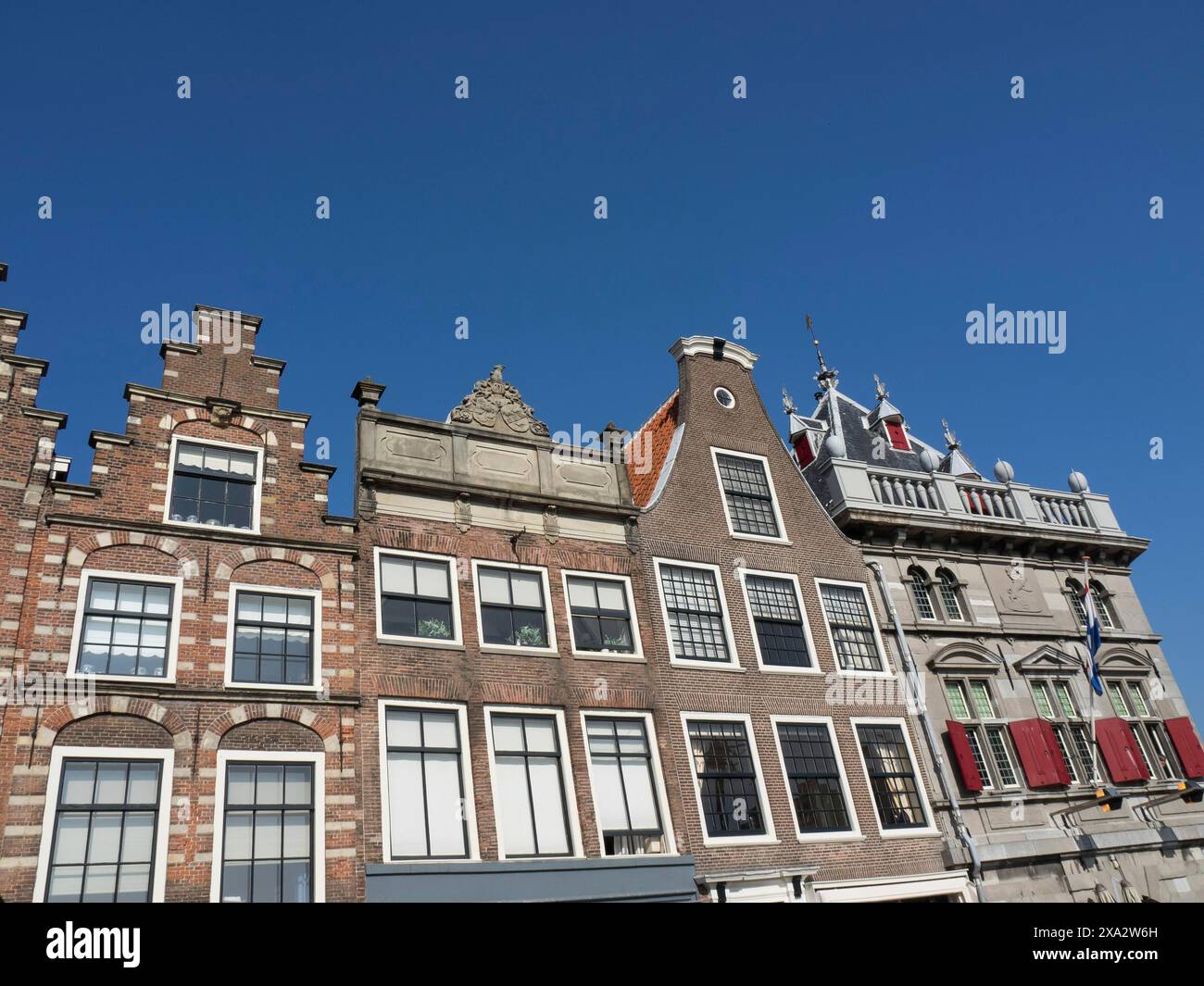 A row of historic buildings with striking facades under a bright blue ...