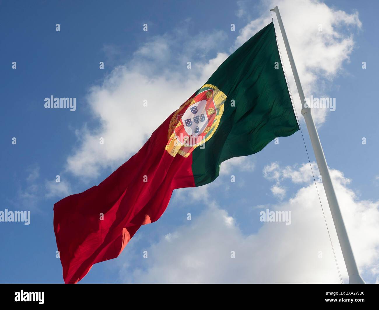 Portuguese flag in the colours green, red and yellow waving in the wind ...