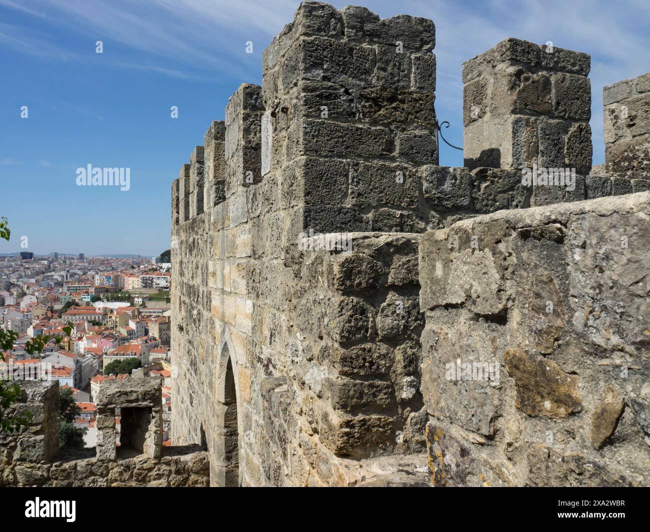 Robust, stone castle wall with battlements, offers a view of the city ...