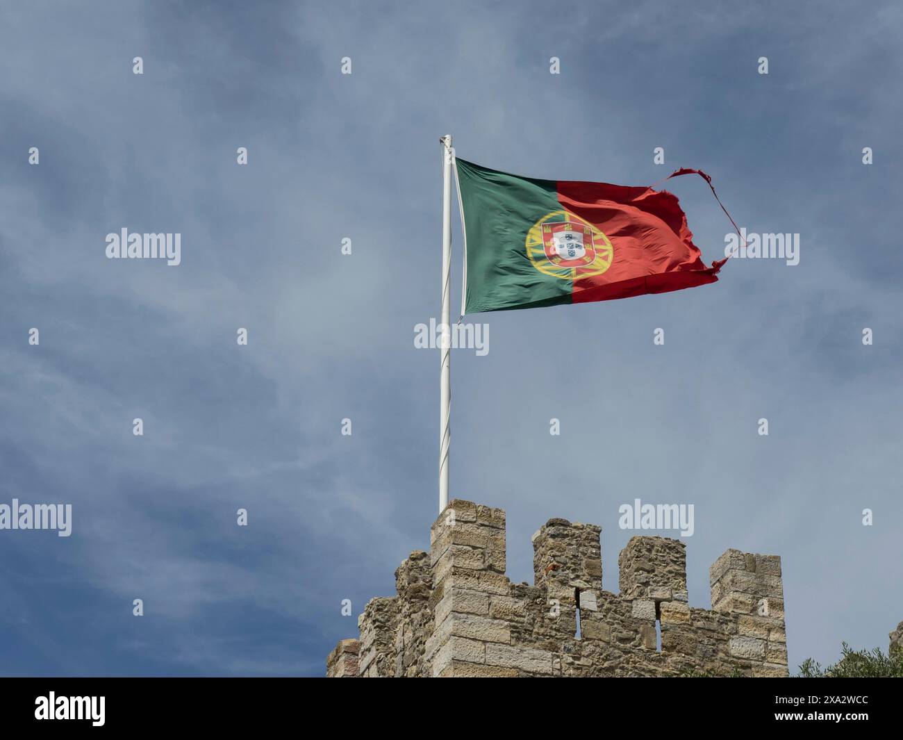 Portuguese flag flying on a medieval castle tower under a slightly ...