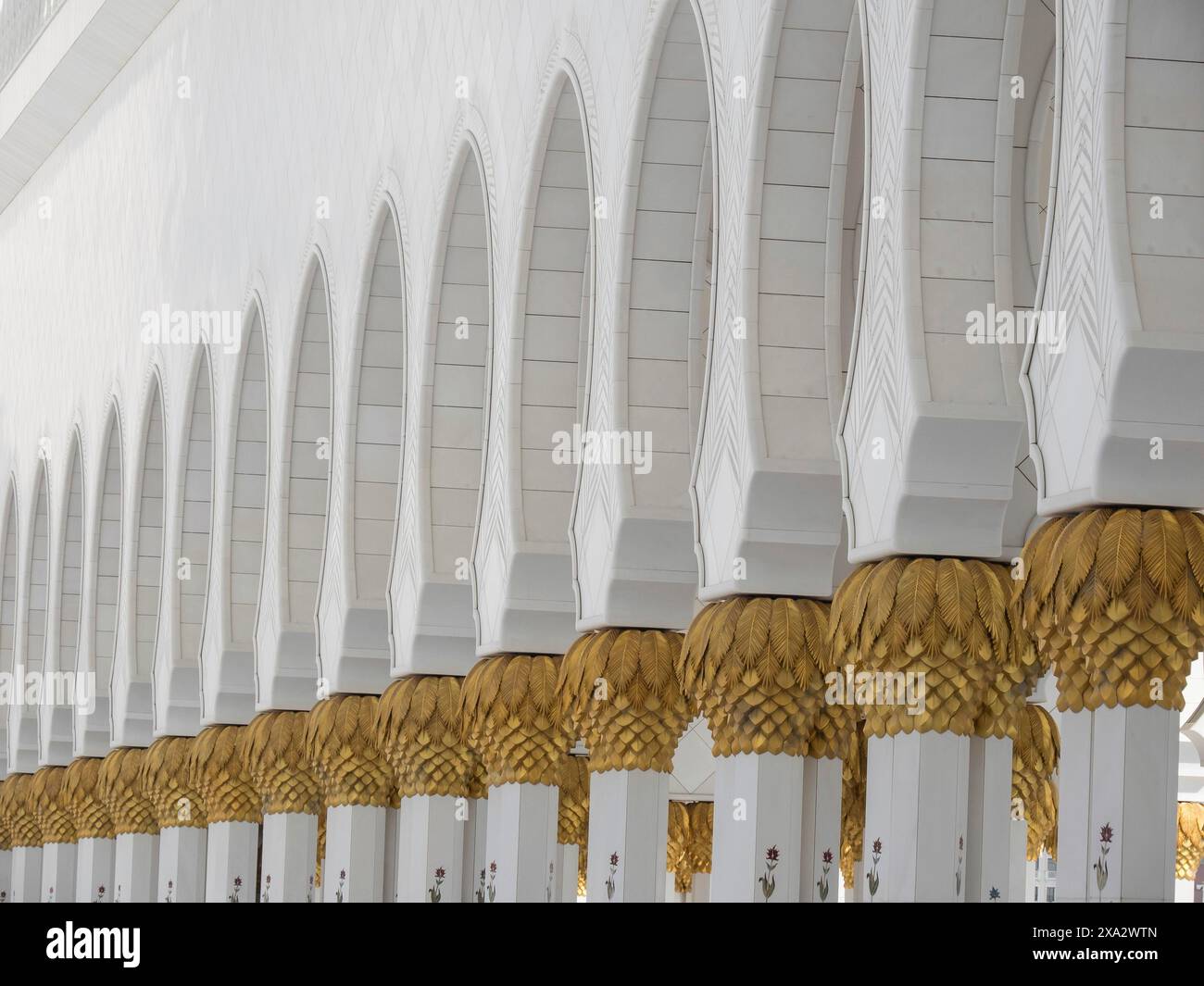 Close-up of arched white columns with golden decorations of Islamic ...