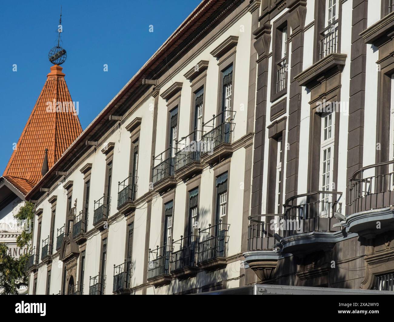 Facade of a classic building with several windows and red roof tiles ...