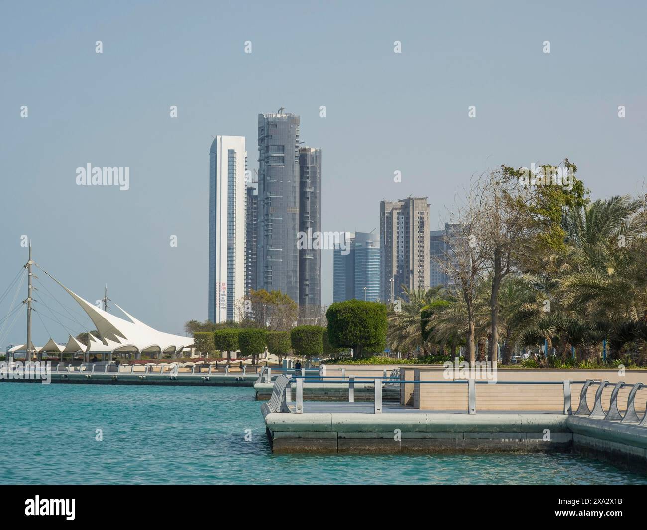 A coastline with modern high-rise buildings and a promenade that runs ...