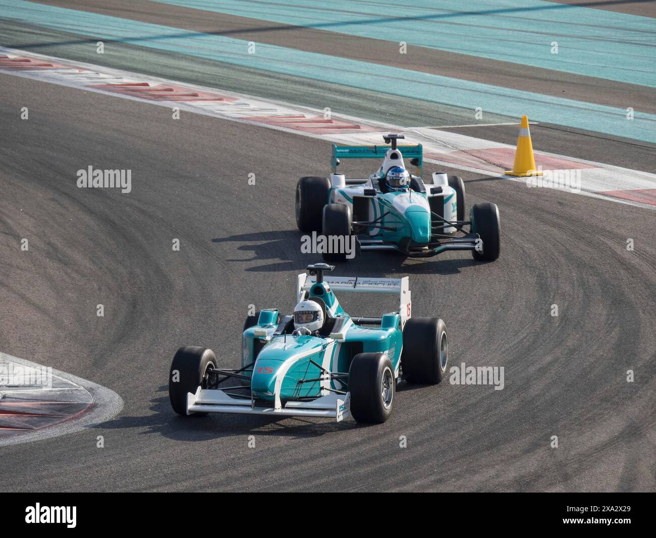 Two racing cars in a curve on the race track under a blue sky in a fast ...