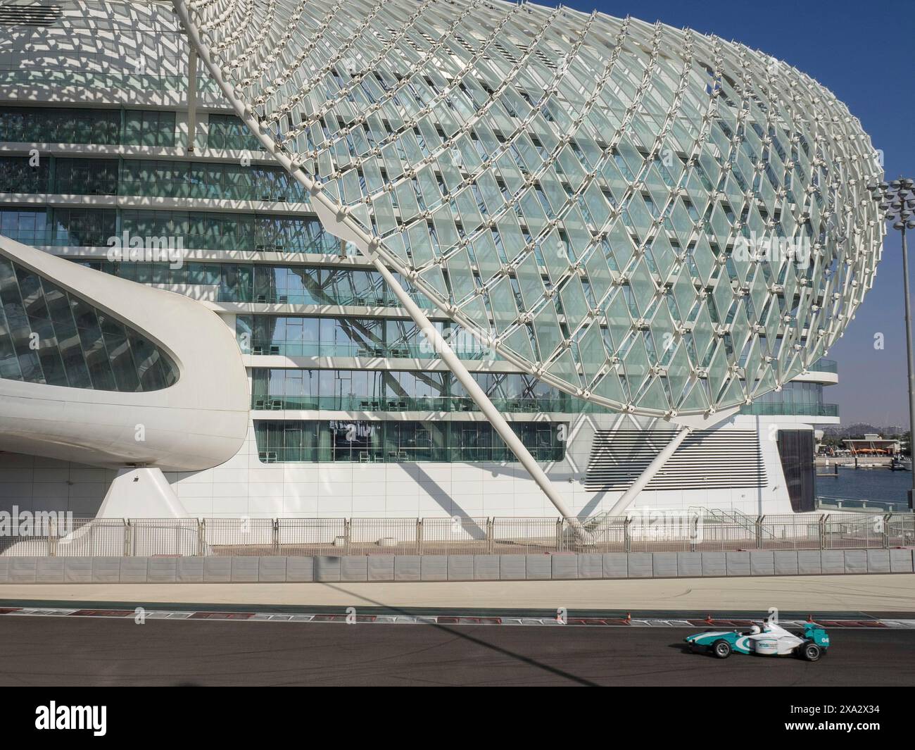 A racing car on a track next to a modern building with an impressive ...