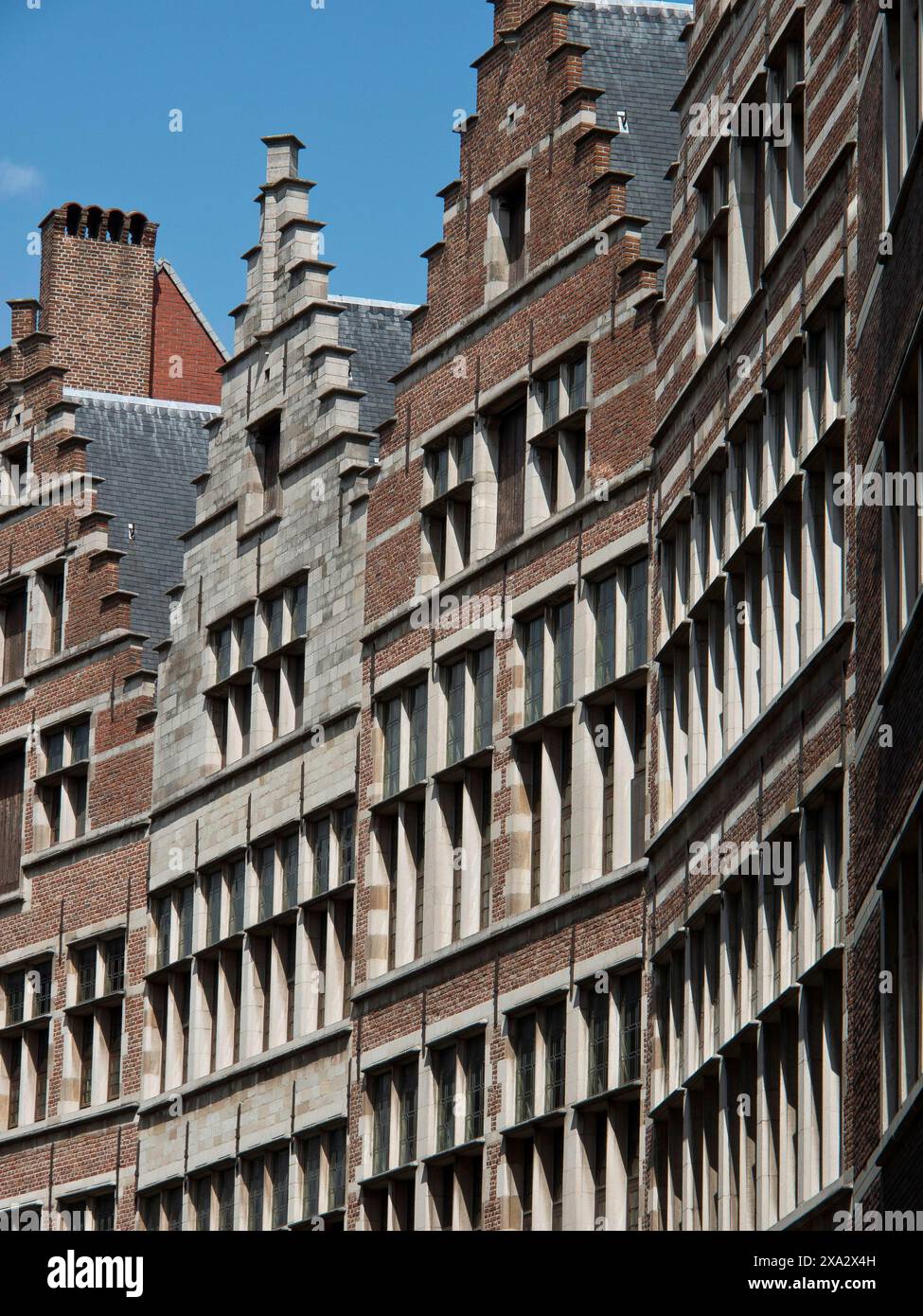 Row of historic brick buildings with stepped gables under a cloudless ...